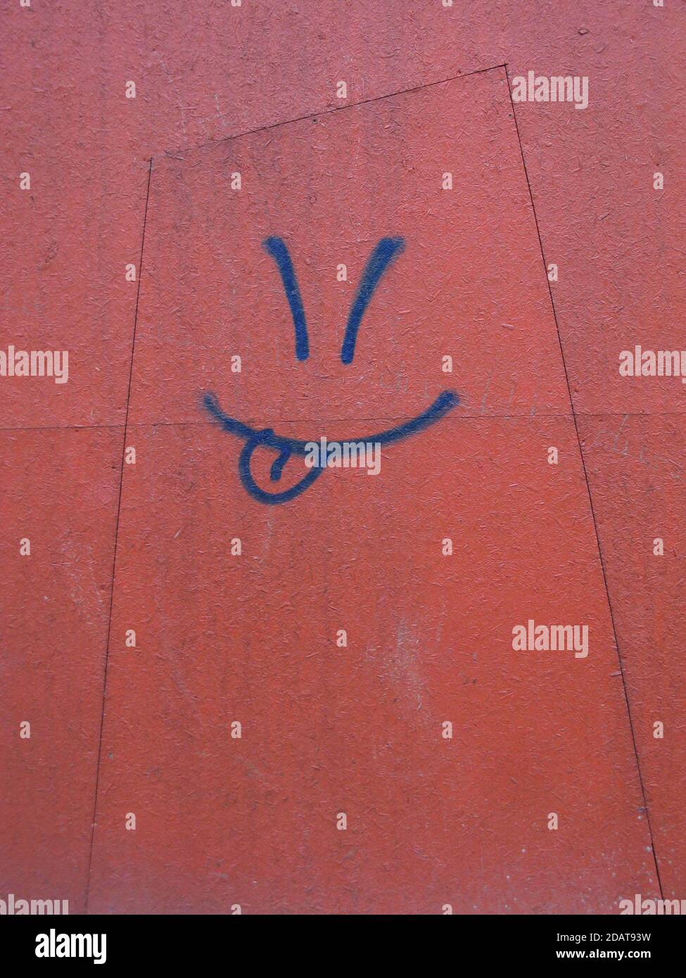 a smiling face on a red wall, symbol for laughter and joy Stock Photo ...