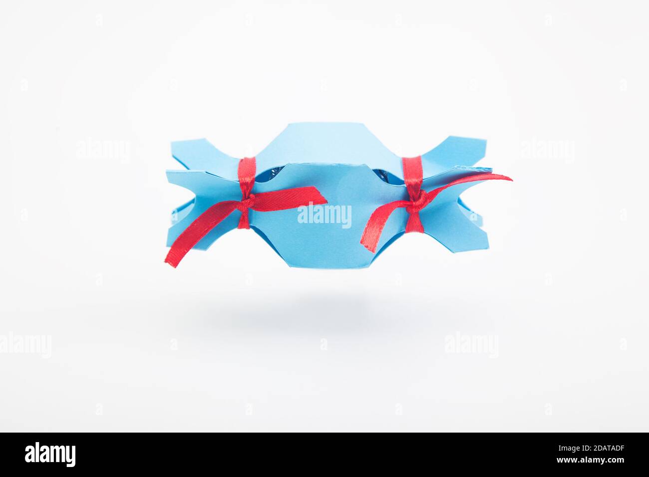 Blue original candy package with red ribbons on white Stock Photo - Alamy