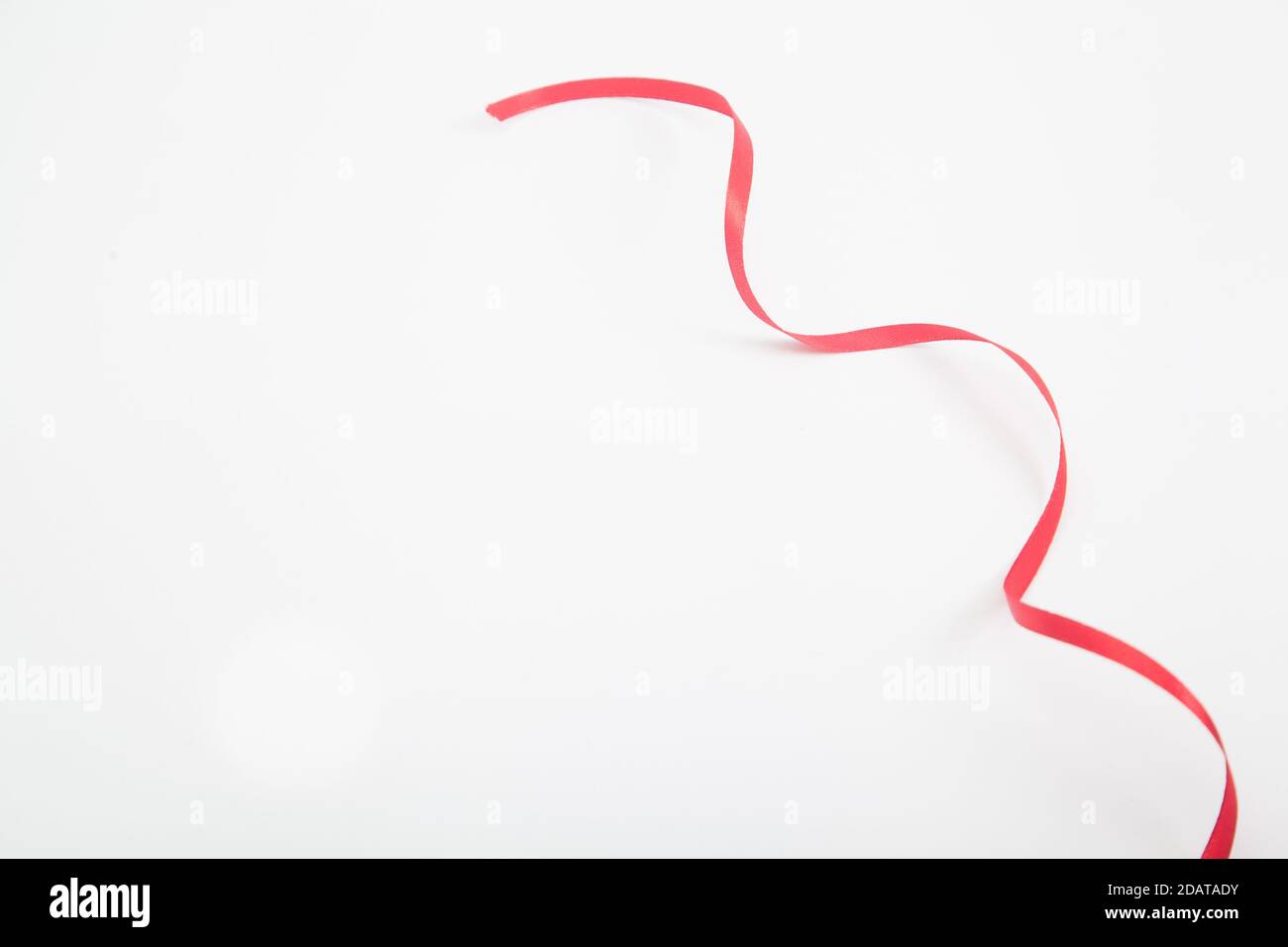 red wavy ribbon on white with copy space Stock Photo - Alamy
