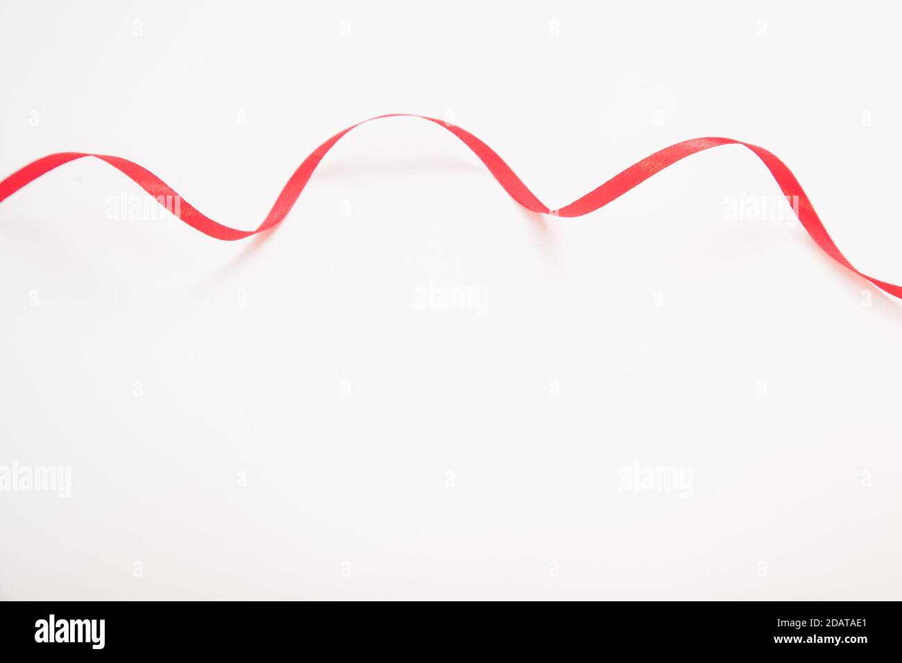 red wavy ribbon on white with copy space Stock Photo - Alamy