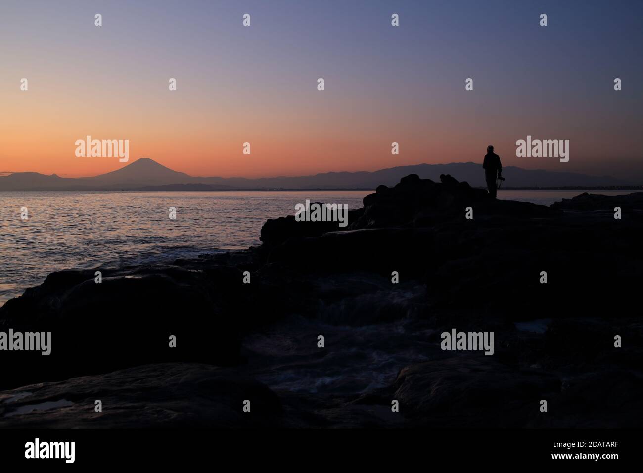 sunset scene of rocky beach, human shilhouette and Mt. Fuji, natural ...