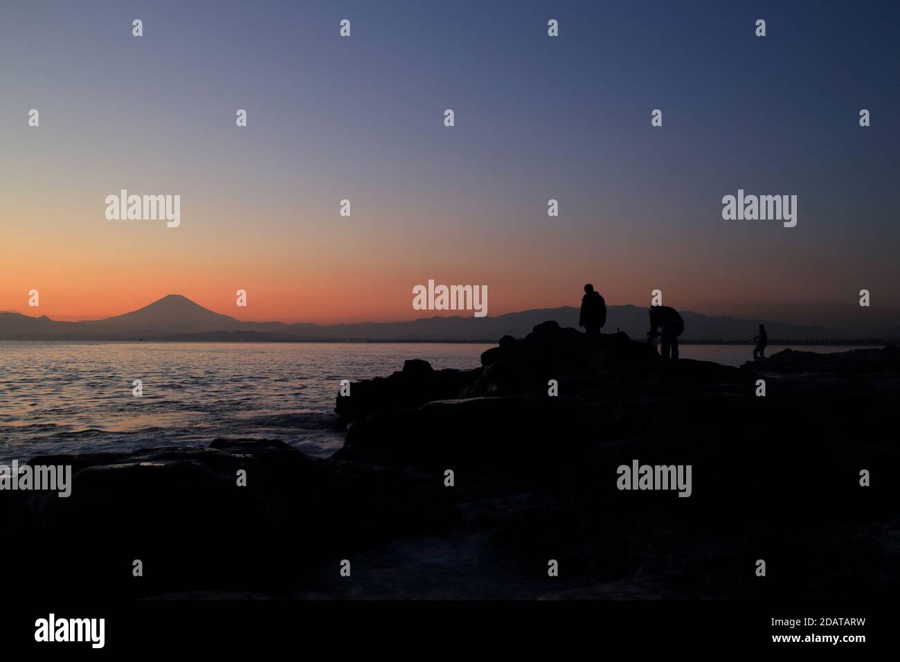 sunset scene of rocky beach, human shilhouette and Mt. Fuji, natural ...