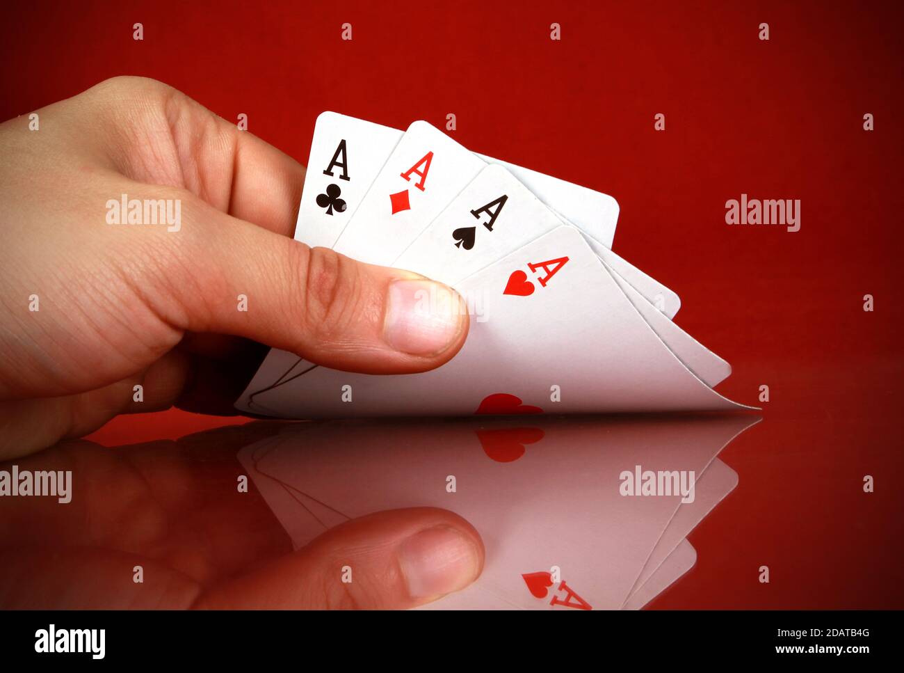 Person playing cards with four of a kind in the hand Stock Photo - Alamy