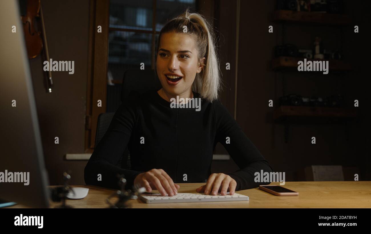 Young blond beautiful woman dressed in black spends time on the ...