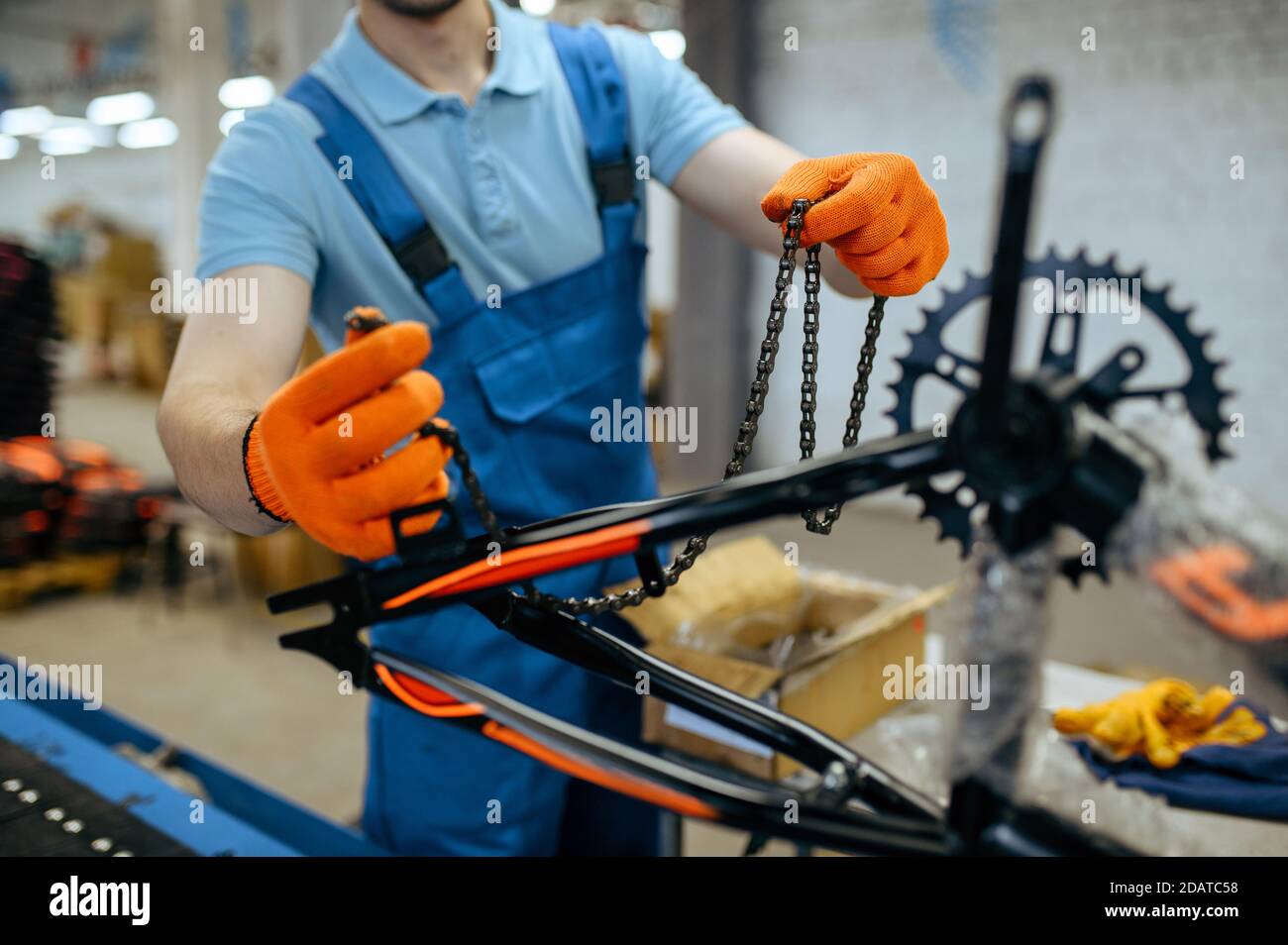 Bicycle factory, worker holds bike chain Stock Photo - Alamy