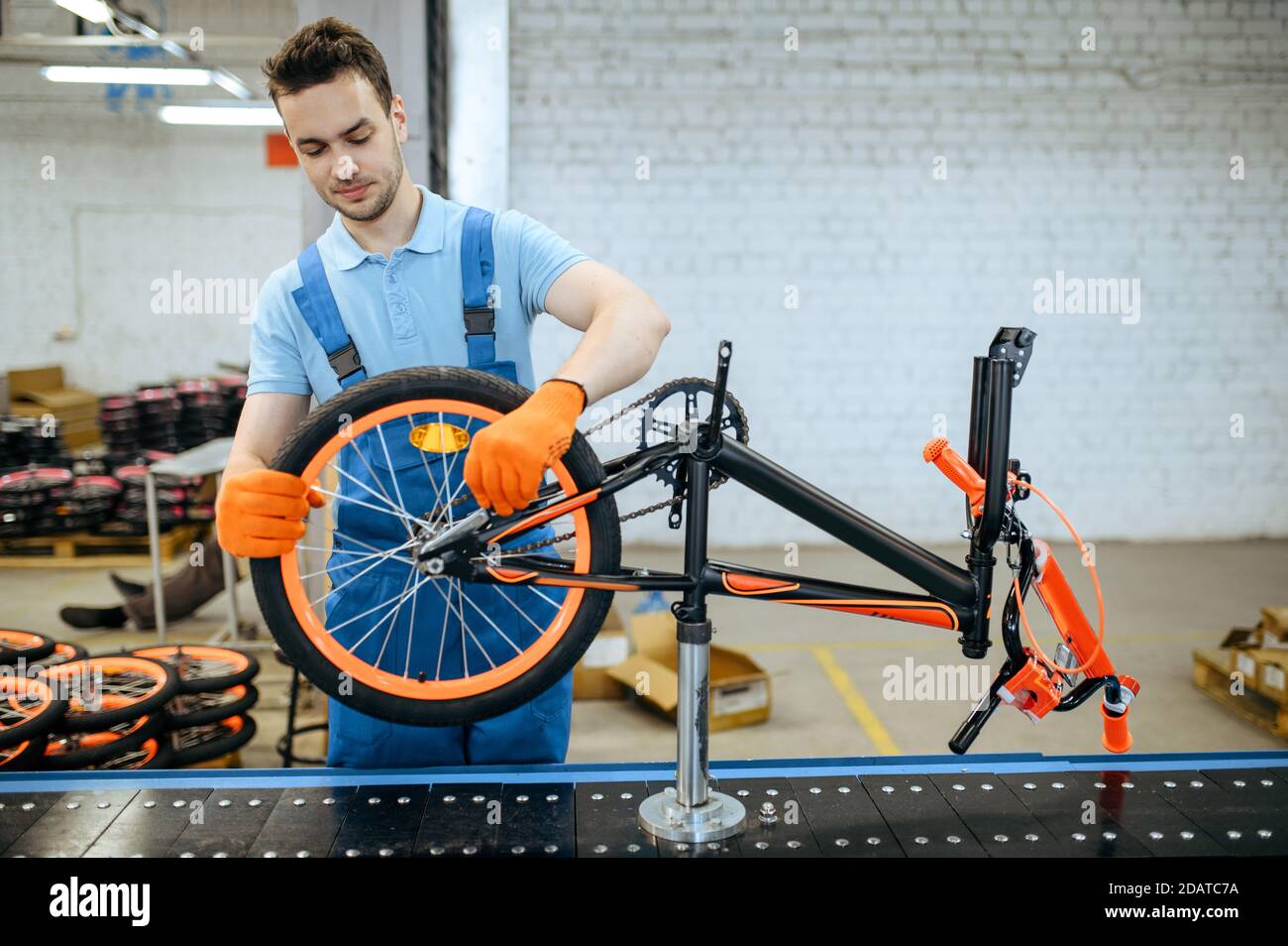 Bicycle factory, assembly line, wheel installation Stock Photo - Alamy