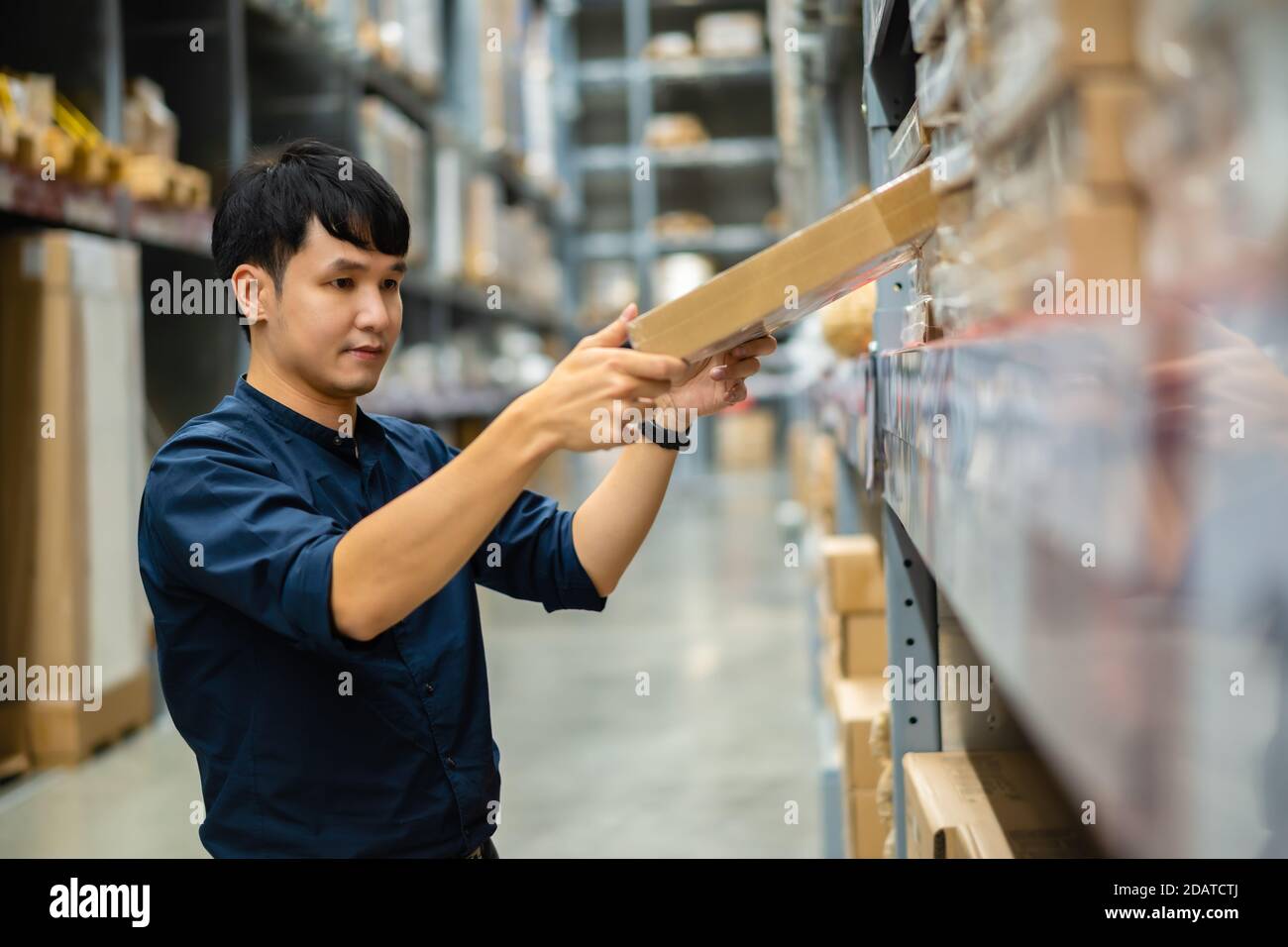 young man worker checking inventory in the warehouse store Stock Photo ...
