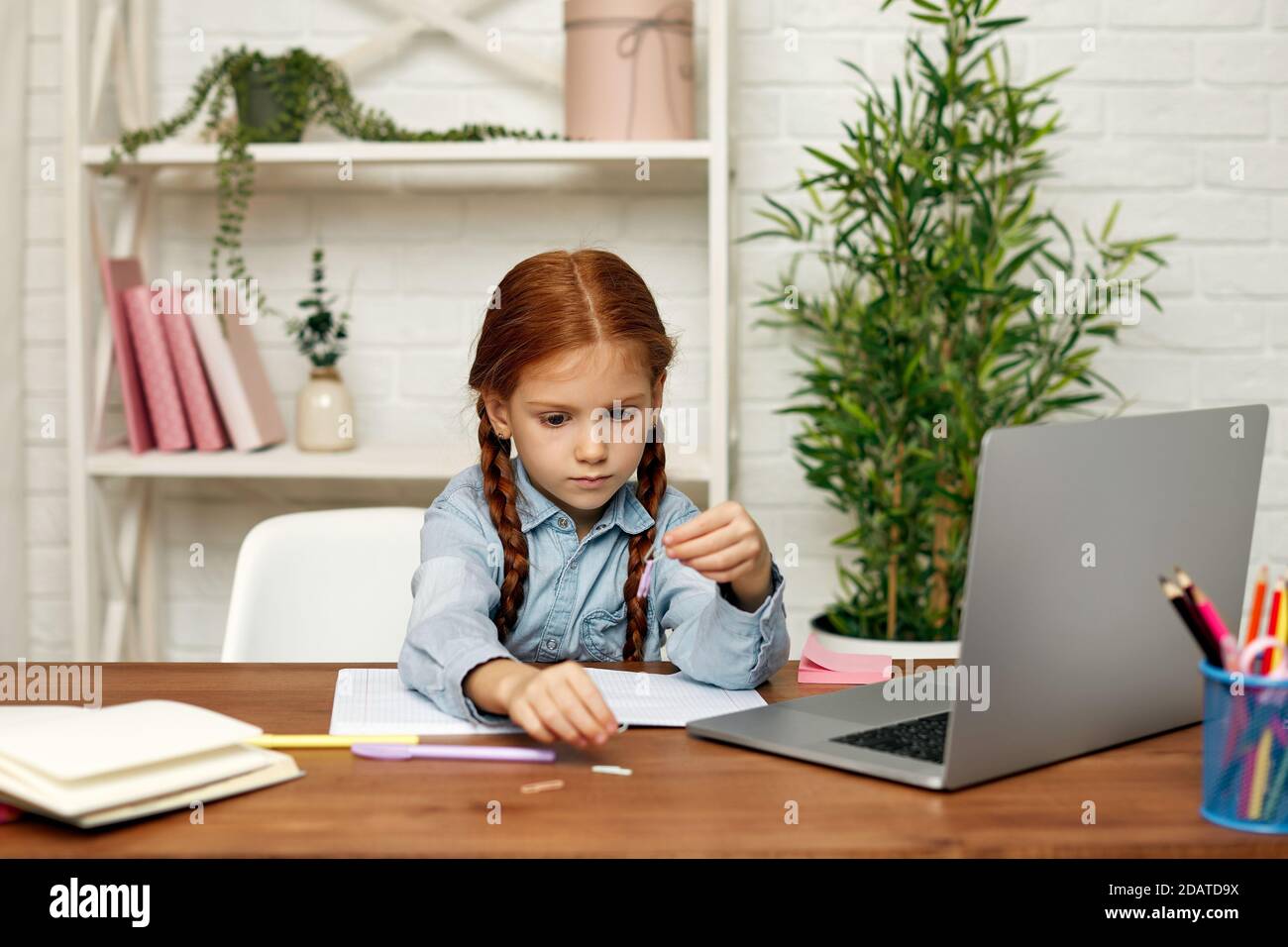 happy redhead little child girl using laptop for studying online ...