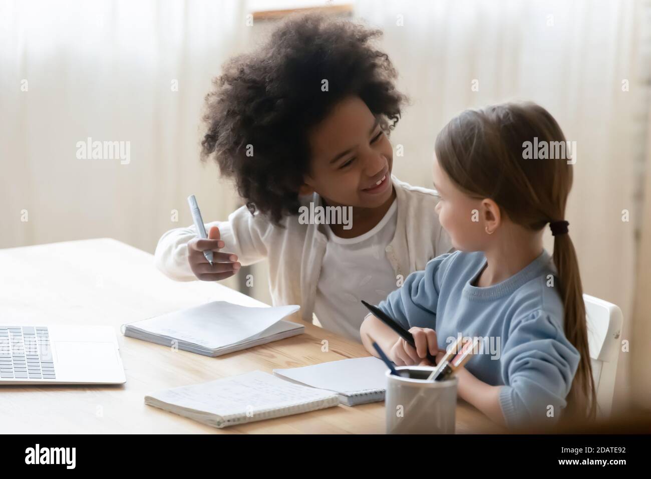 Two diverse little girls doing school tasks, homework together Stock ...