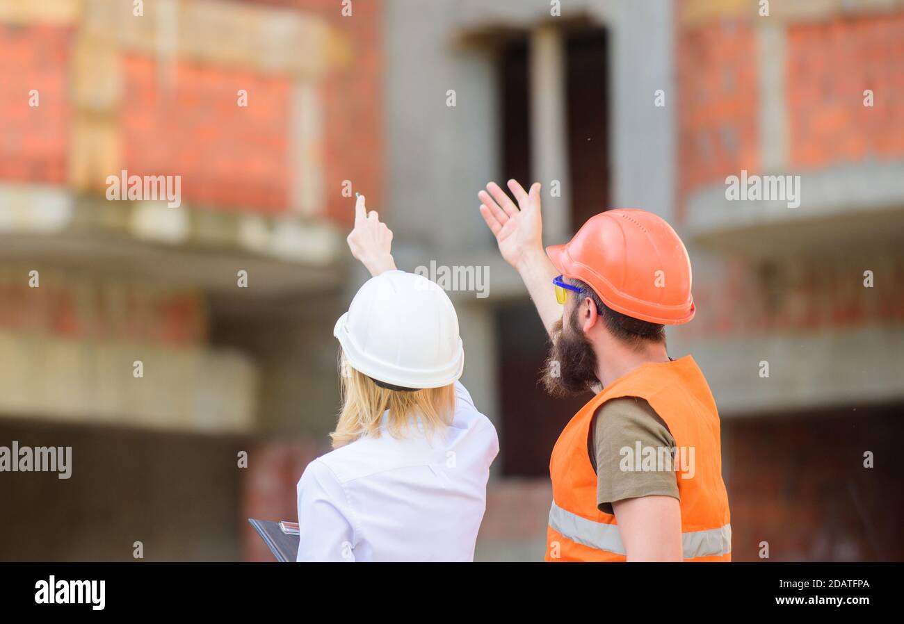Woman engineer and builder communicate construction site. Relationships ...