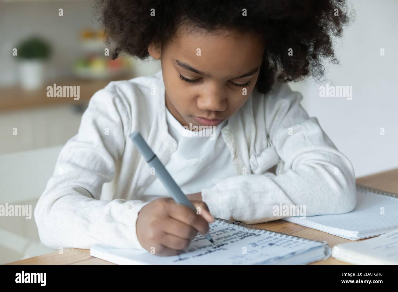Close up focused little African American girl studying at home Stock ...