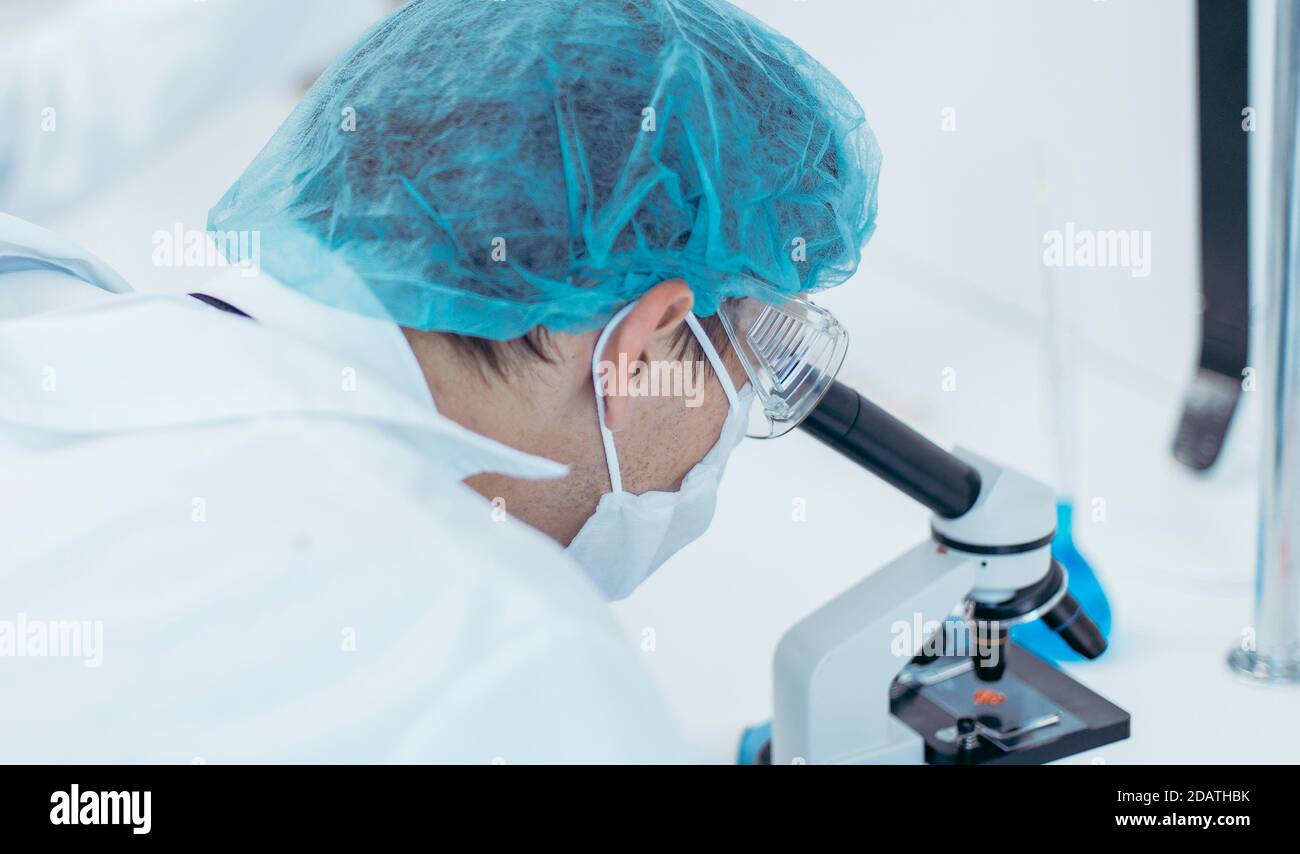 close up. scientist looking through a microscope Stock Photo - Alamy