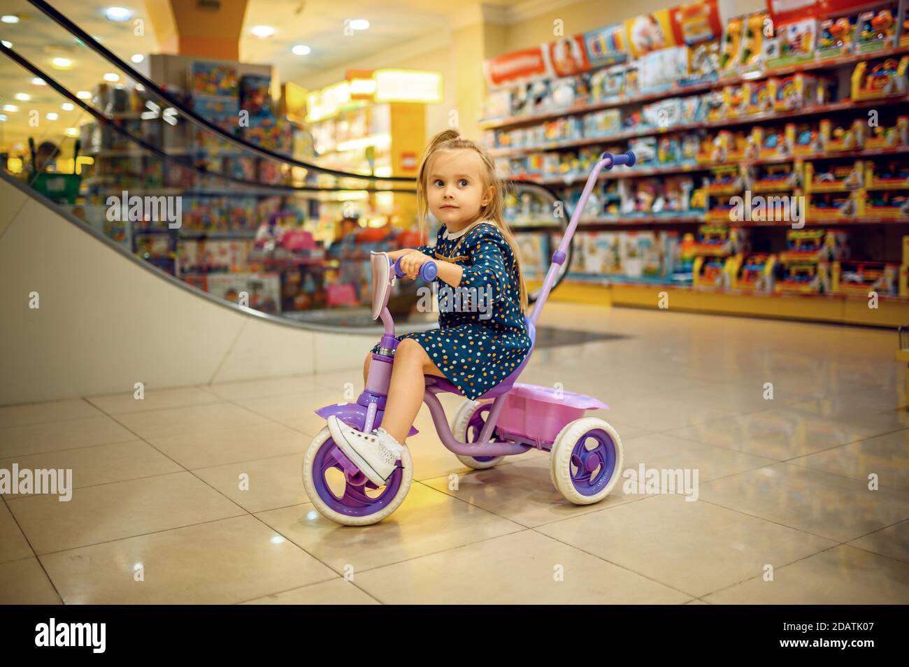 Little baby riding on bicycle in children's shop Stock Photo - Alamy