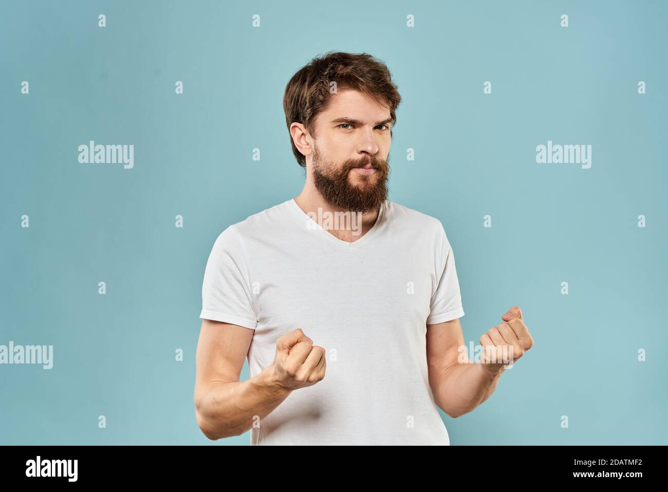 Man gestures with his hands emotions displeasure white t-shirt blue ...
