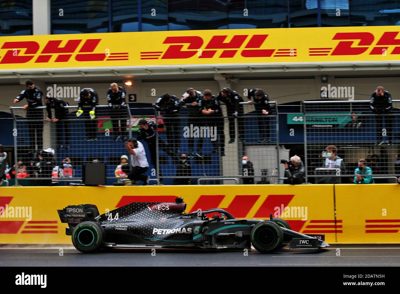 Lewis Hamilton (GBR) Mercedes AMG F1 W11 crosses the line watched by ...