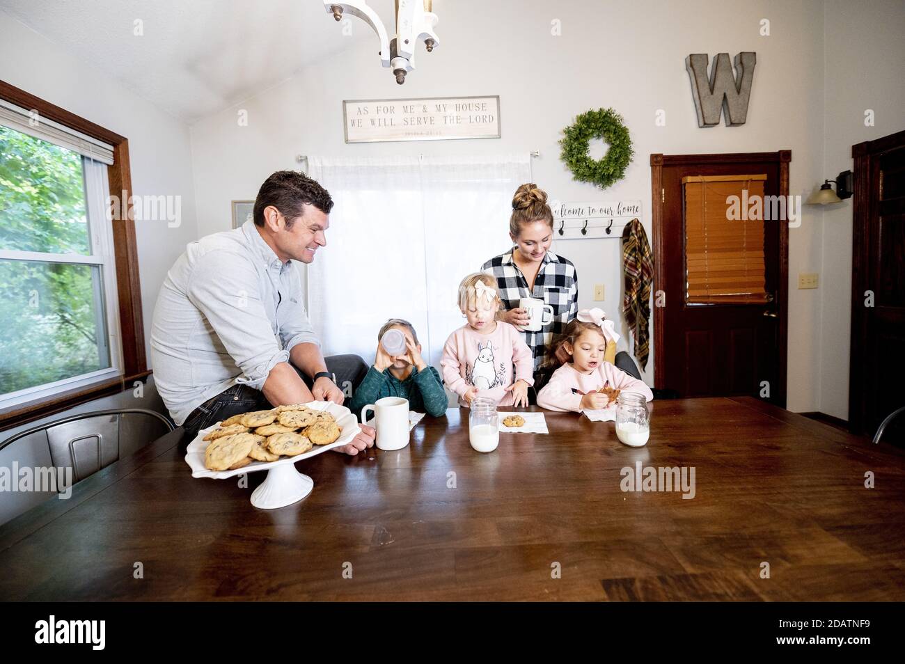 Happy family eating cookies and drinking milk Stock Photo - Alamy