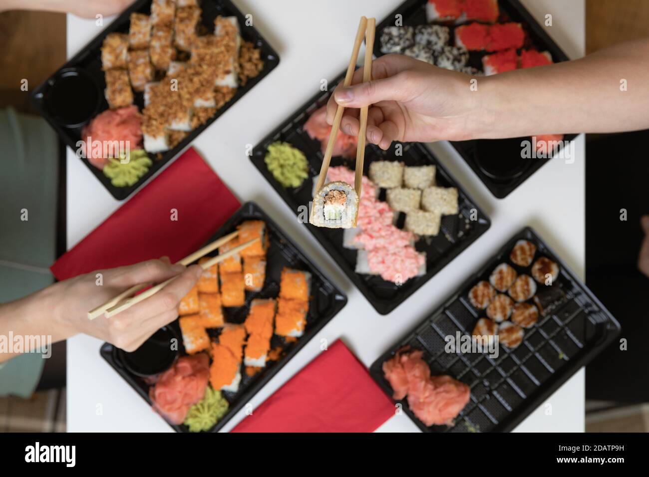Two women friends sitting by table and eating sushi. Family, friendship ...