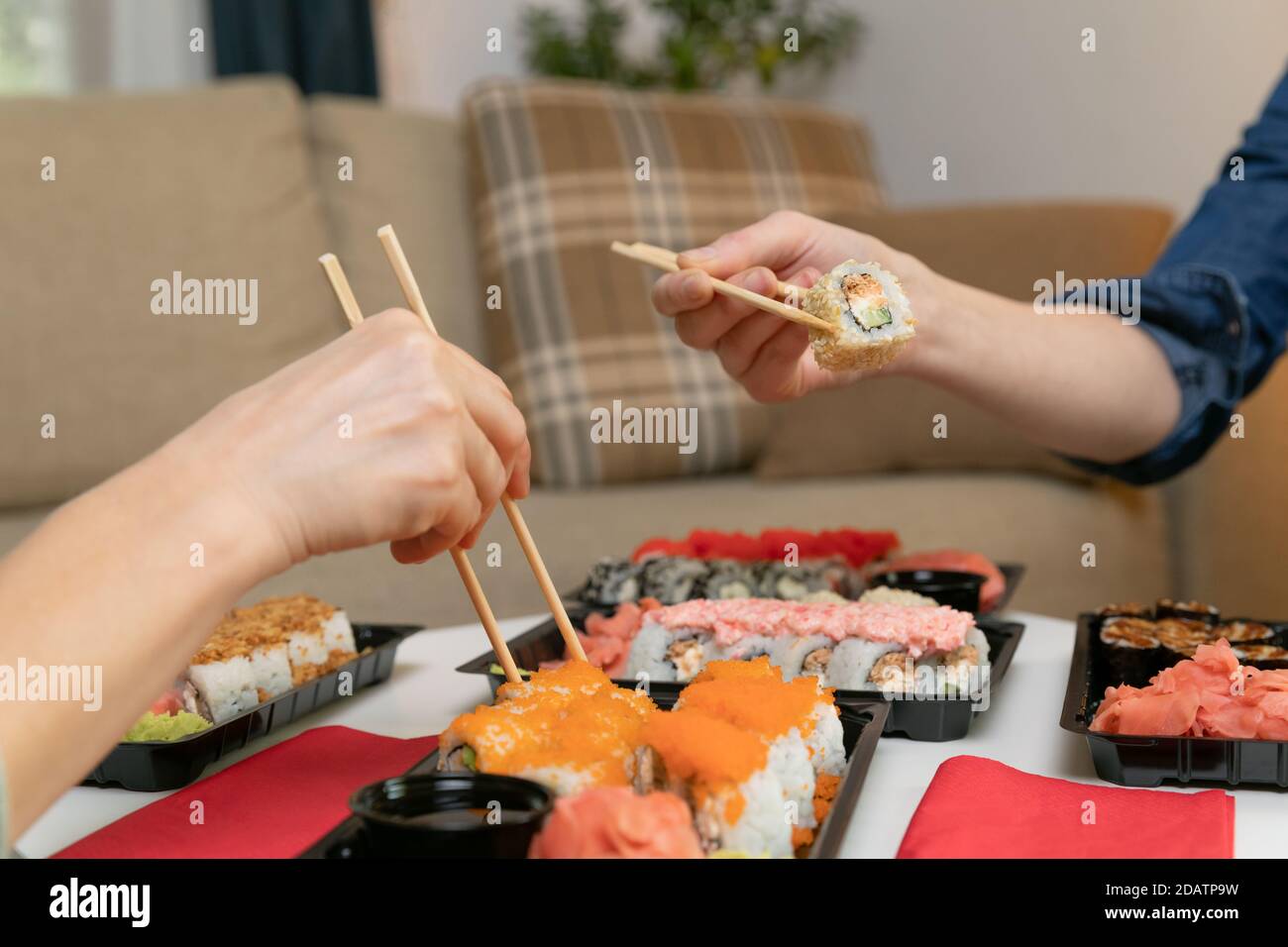 Two women friends sitting by table and eating sushi. Family, friendship ...