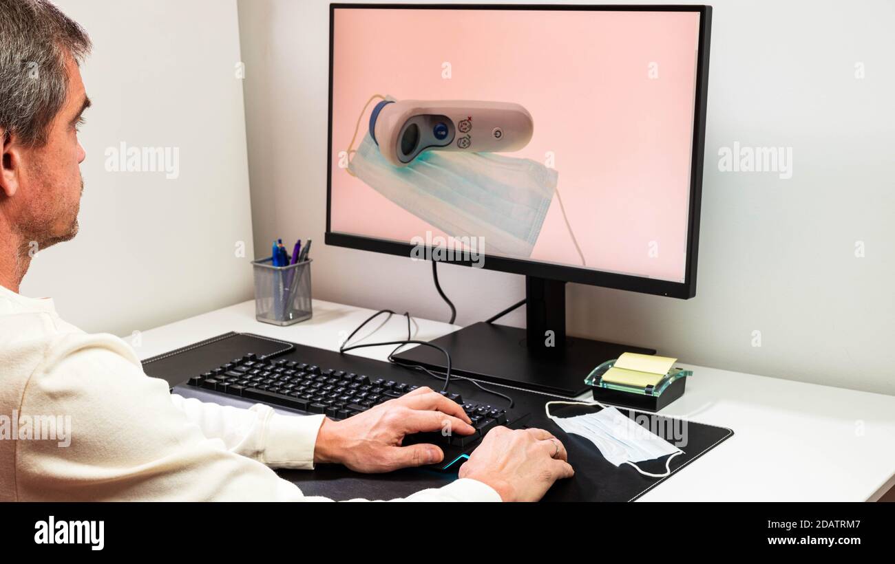 View of man using computer monitor with image face mask and kind of ...