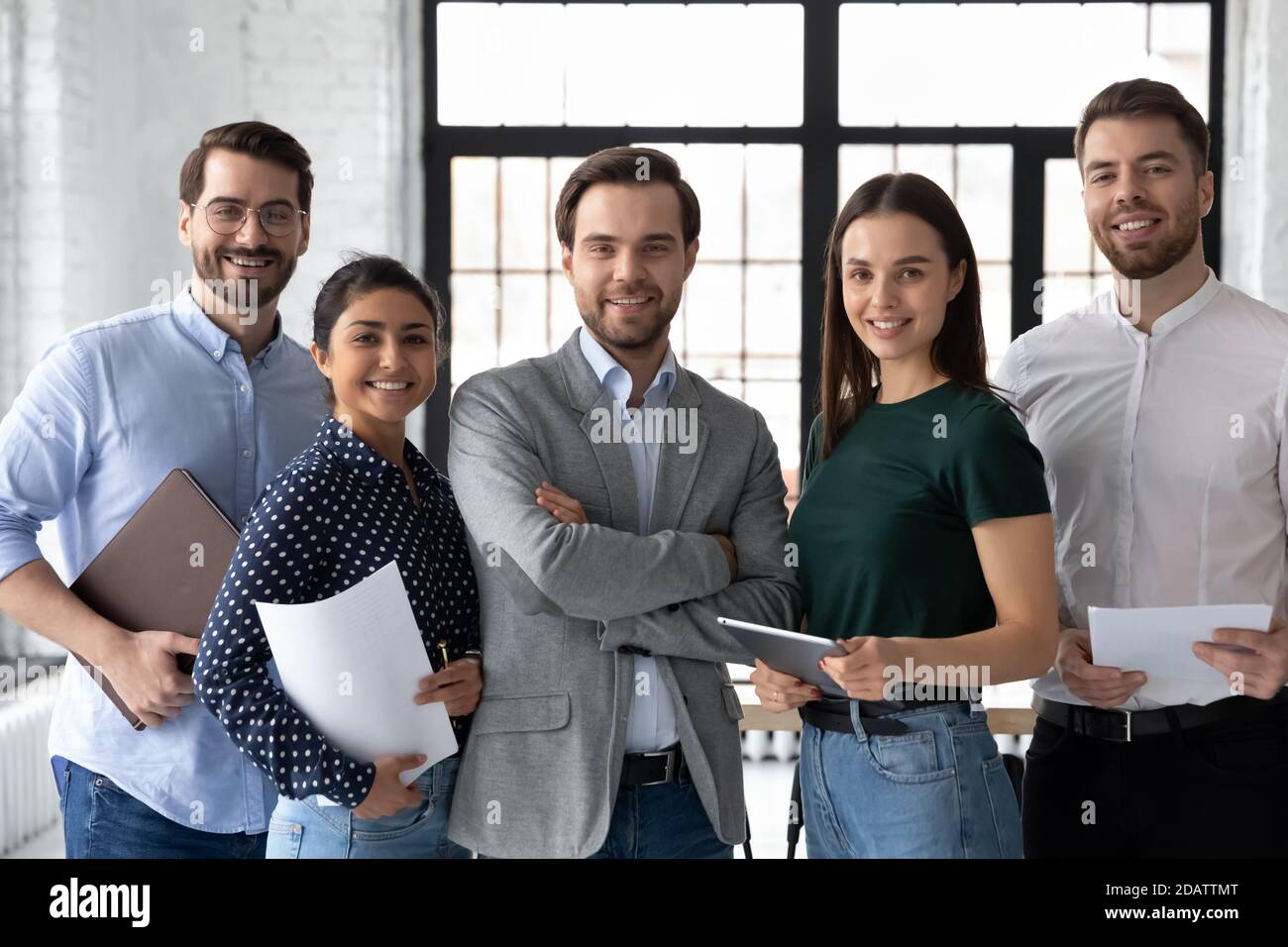 Confident male team leader posing for portrait with diverse employees ...