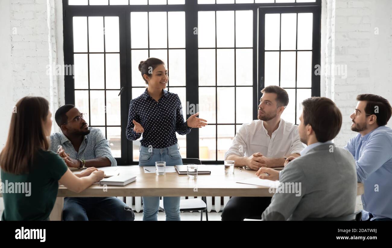 Indian female coach delivering training to diverse group of employees ...