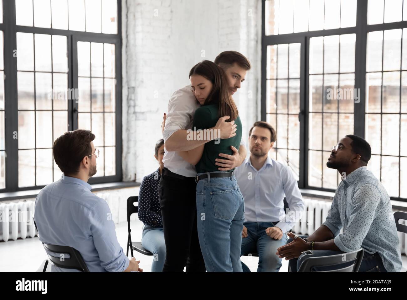 Sad male and female hugging one another on group therapy Stock Photo ...