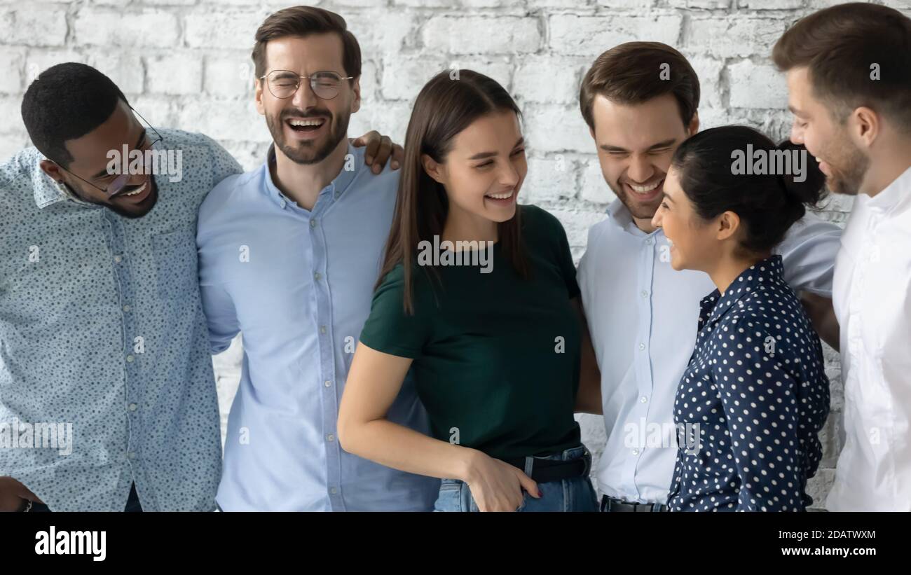 Overjoyed millennial multiethnic friends gathered together on informal ...