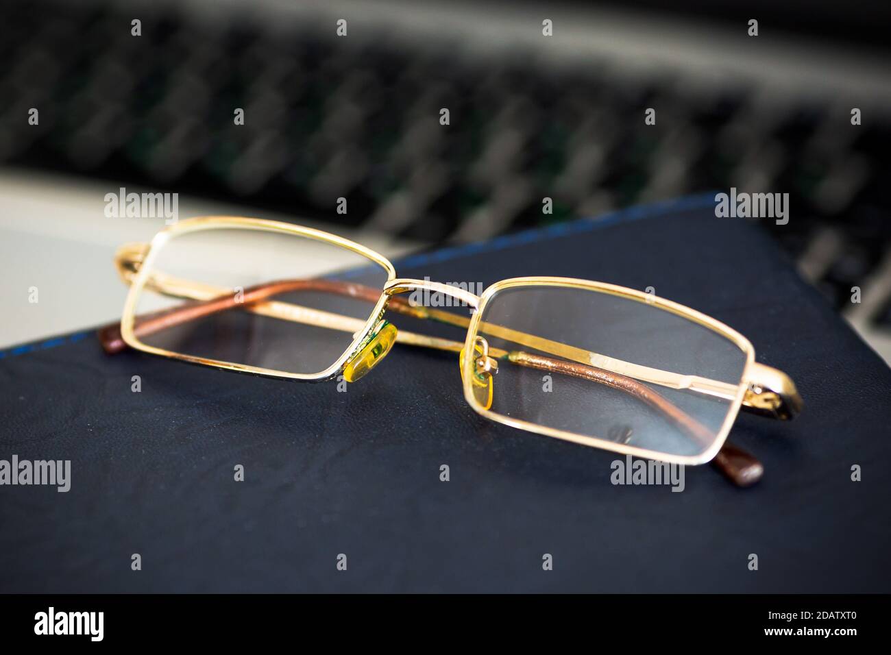 Gold rimmed eyeglasses for office workplace. Close-up Stock Photo - Alamy