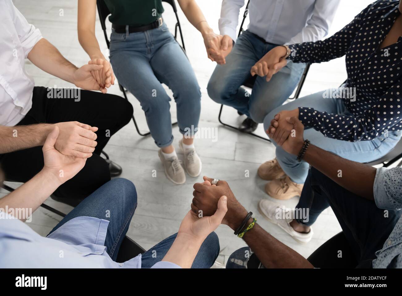 Diverse people group sitting on chairs in circle uniting hands Stock ...