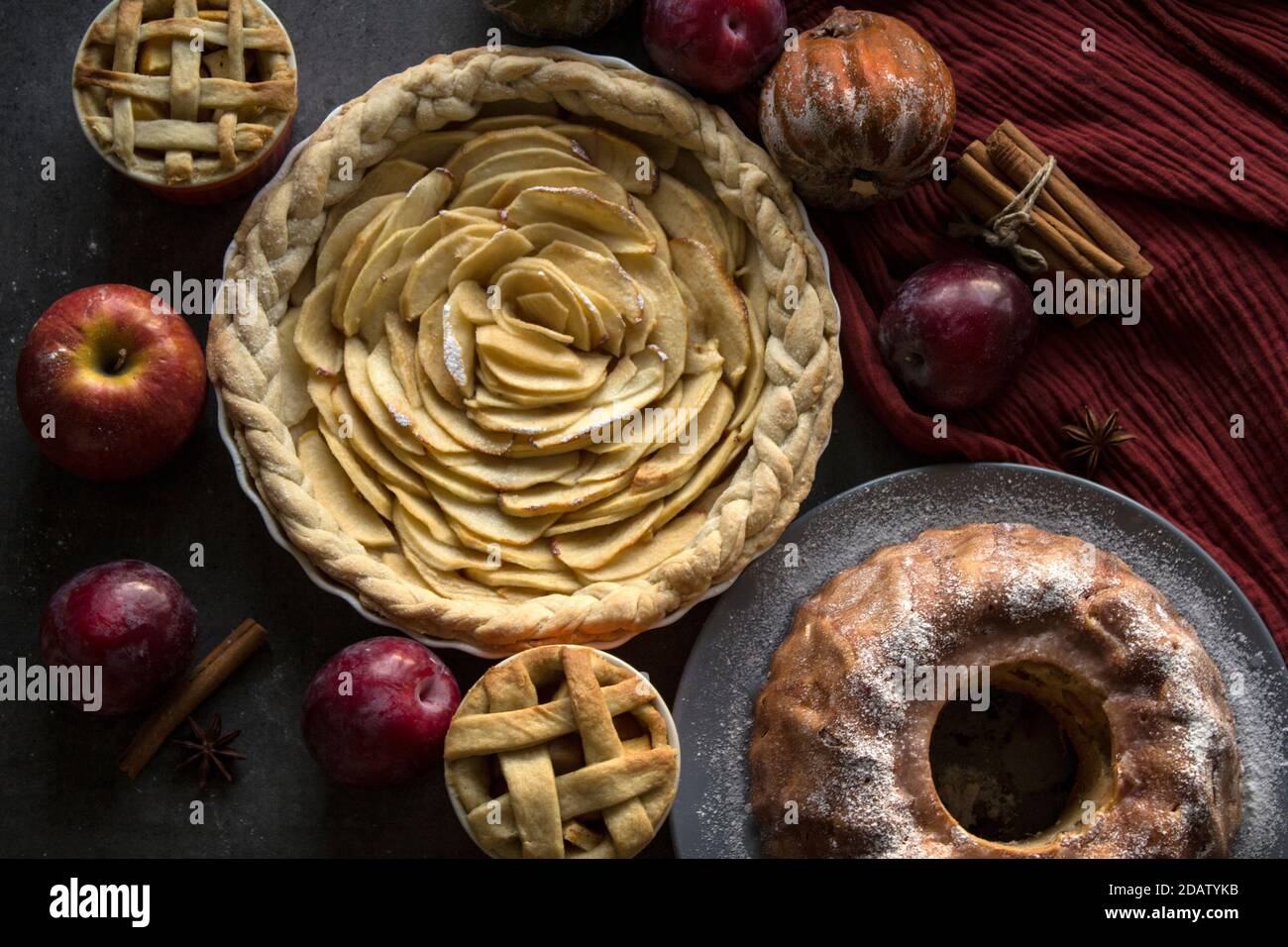 Apple pies of different types on a table with fresh fruits, cinnamon ...