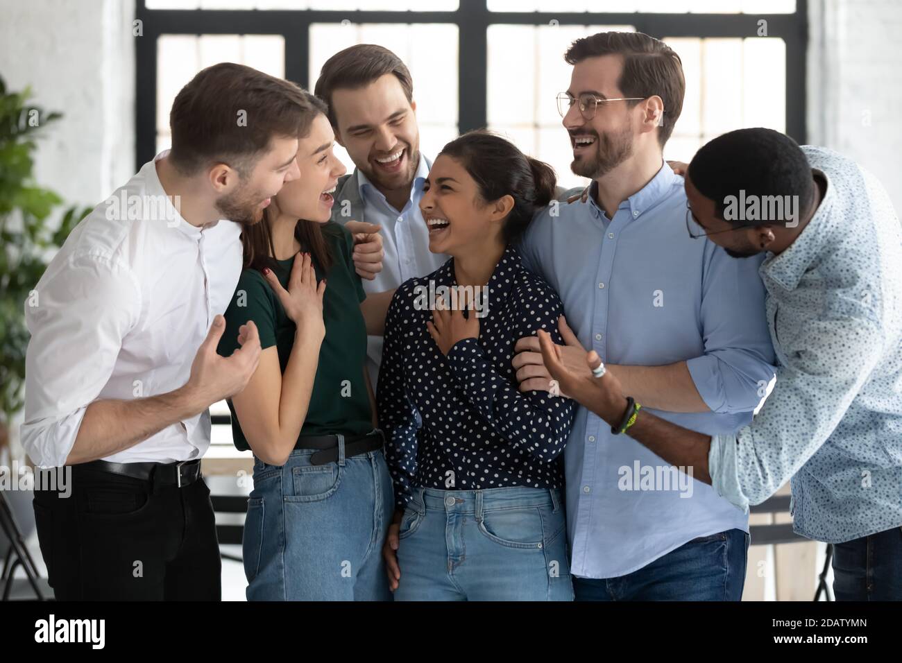Happy diverse millennial friends greeting indian female mate with ...