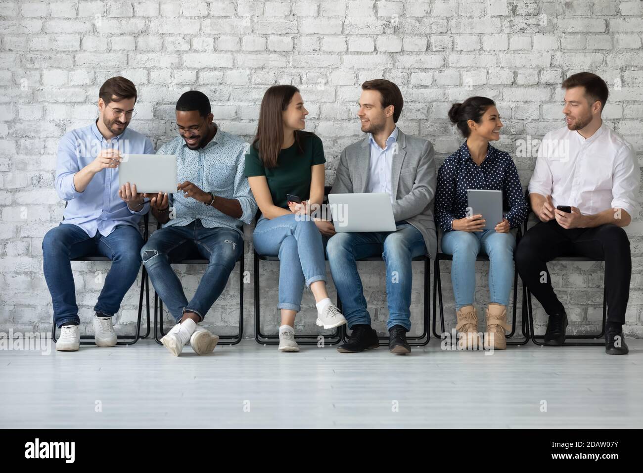 Diverse people of millennial generation talking and using electronic ...