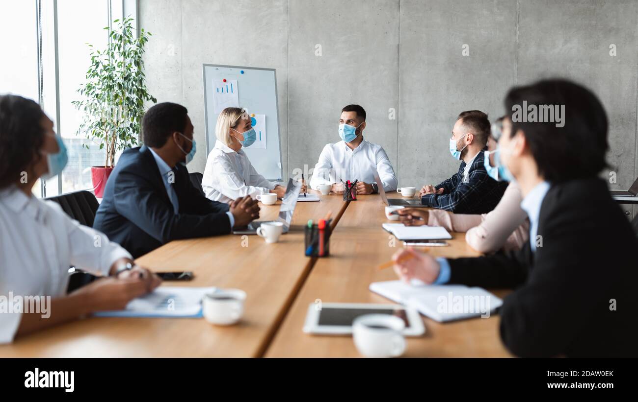 People In Face Masks Sitting During Corporate Meeting In Office Stock ...