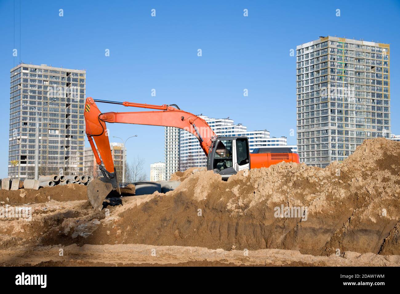 Excavator during earthmoving at construction site on blue sky ...