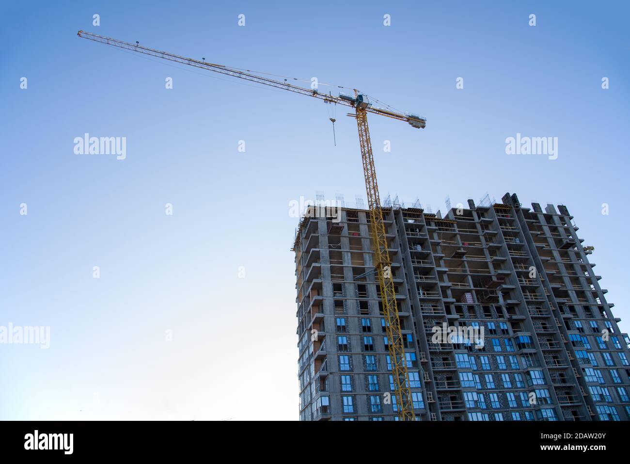 Tower crane working at construction site on blue sky background with ...
