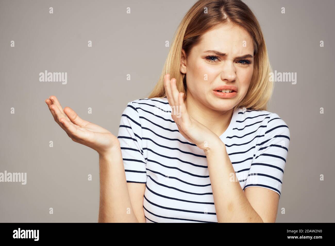 A woman with a displeased expression is gesturing with her hands T ...