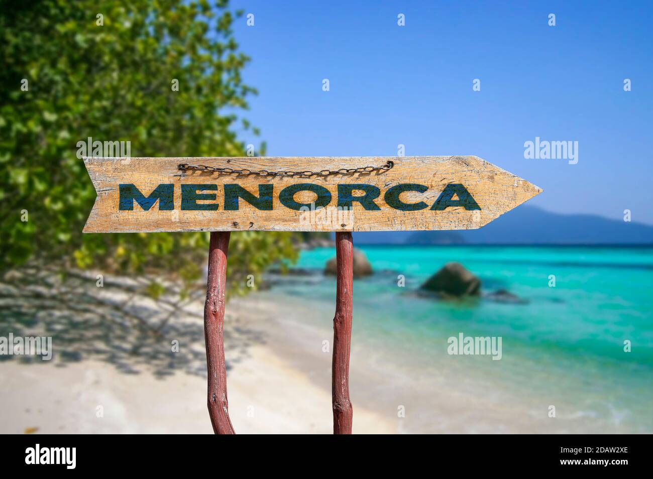 Menorca wooden arrow road sign against tropical beach with white sand ...