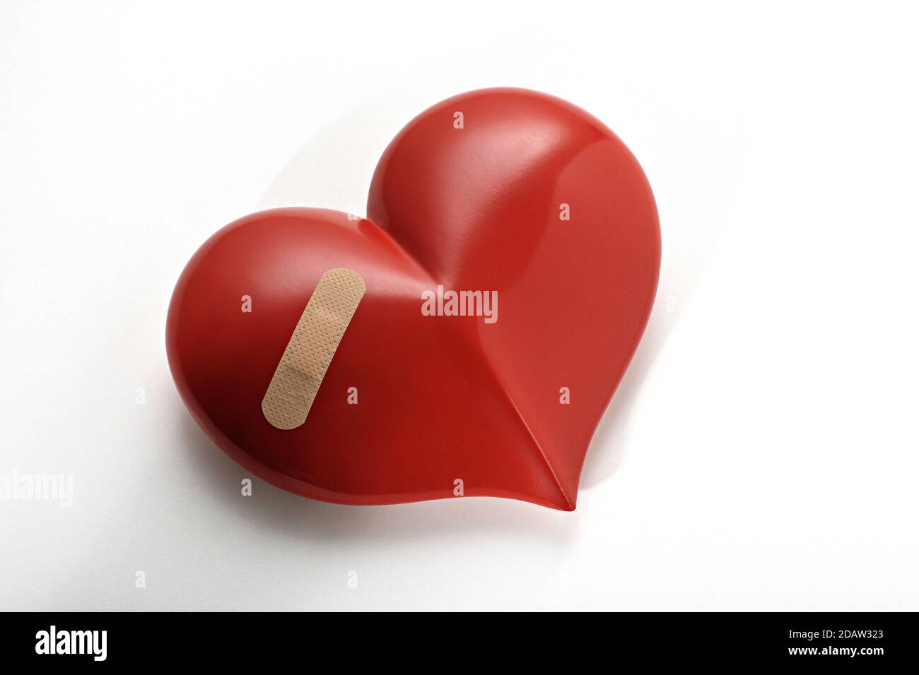 An injured red heart is treated with a medical plaster Stock Photo - Alamy