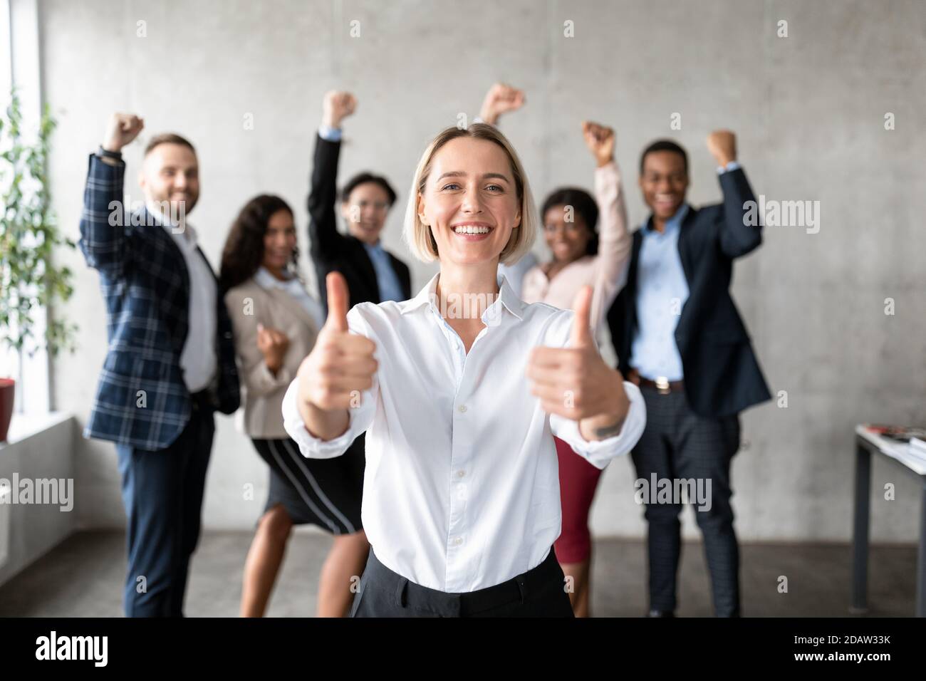Businesswoman Gesturing Thumbs-Up Standing With Joyful Employees Team ...