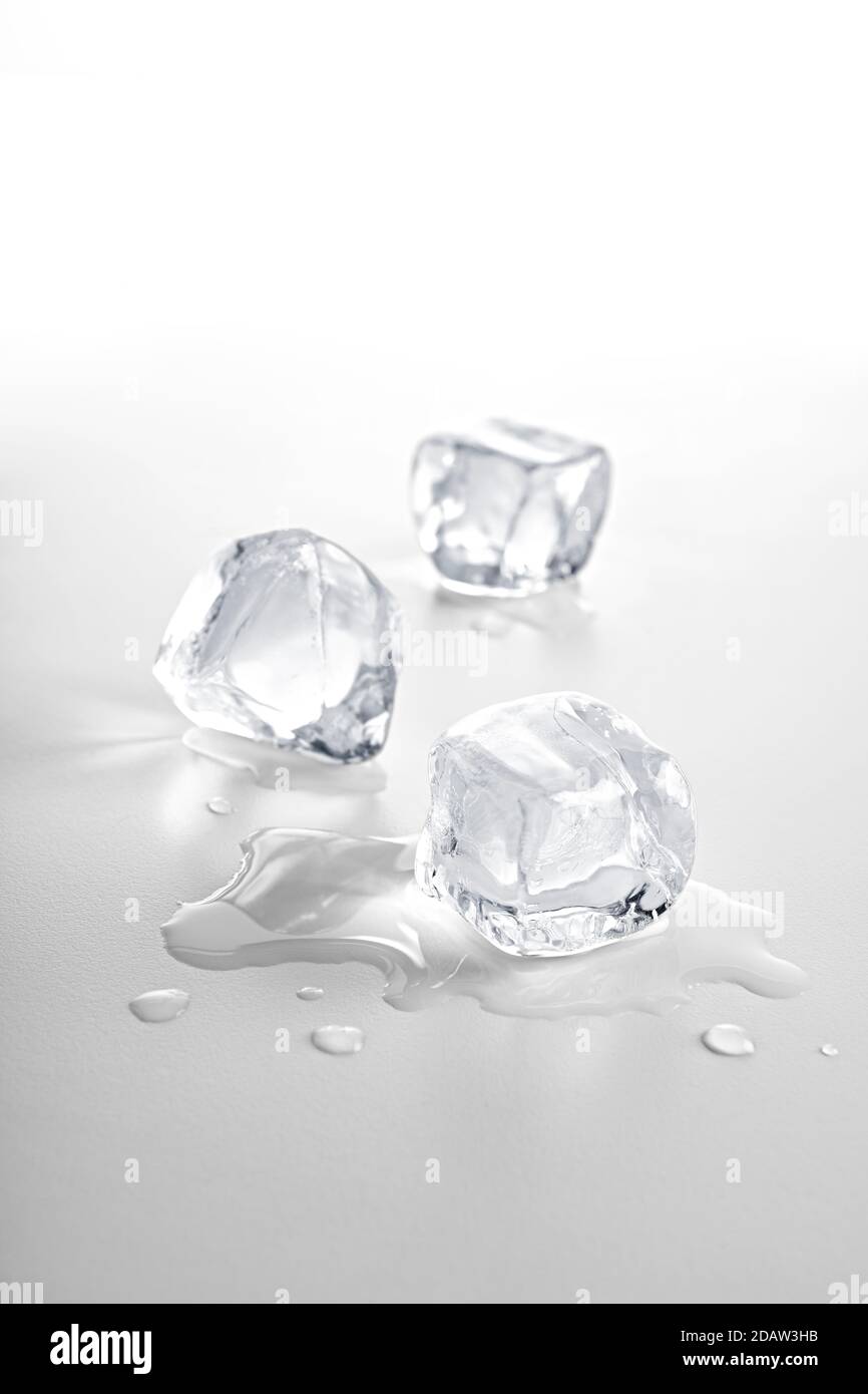 Group of ice cubes in the foreground, over white background, with ...