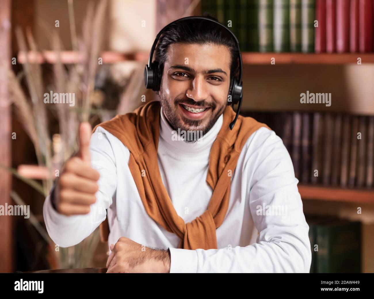 Cheerful Indian Student Guy Gesturing Thumbs Up Sitting Indoor Stock ...