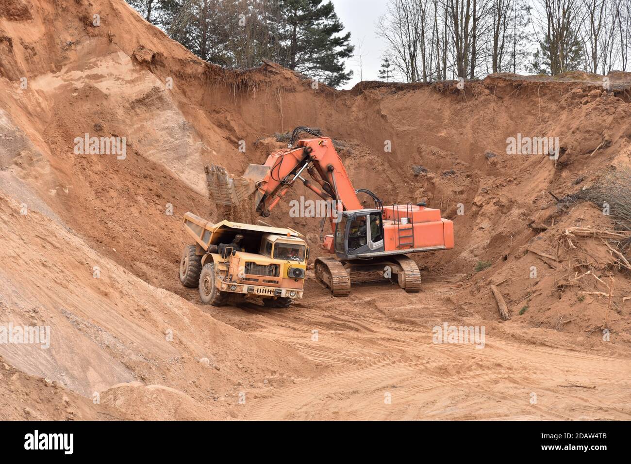 Excavator load the sand to the heavy mining truck in the open-pit ...