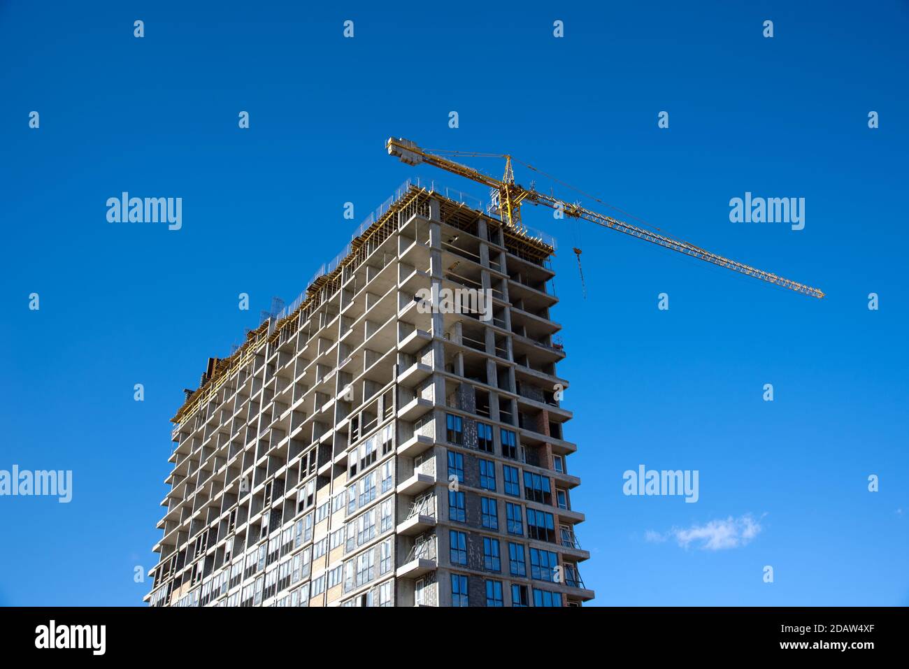 Tower crane working at construction site on blue sky background with ...