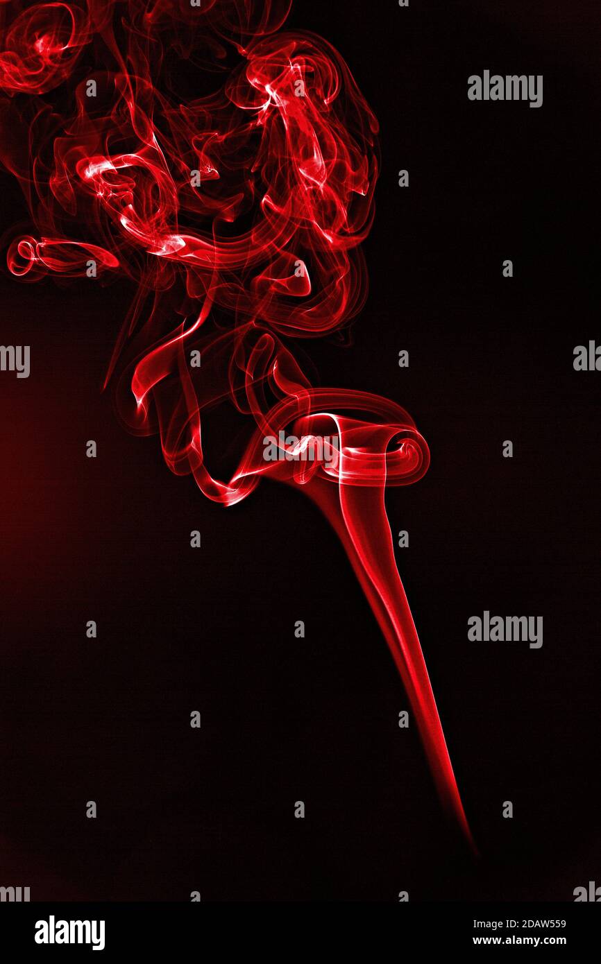 Red smoke rises upwards on a black background Stock Photo - Alamy