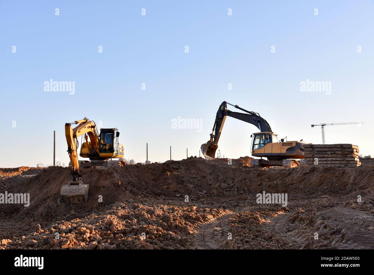 Excavators working at construction site. Backhoe during earthworks ...