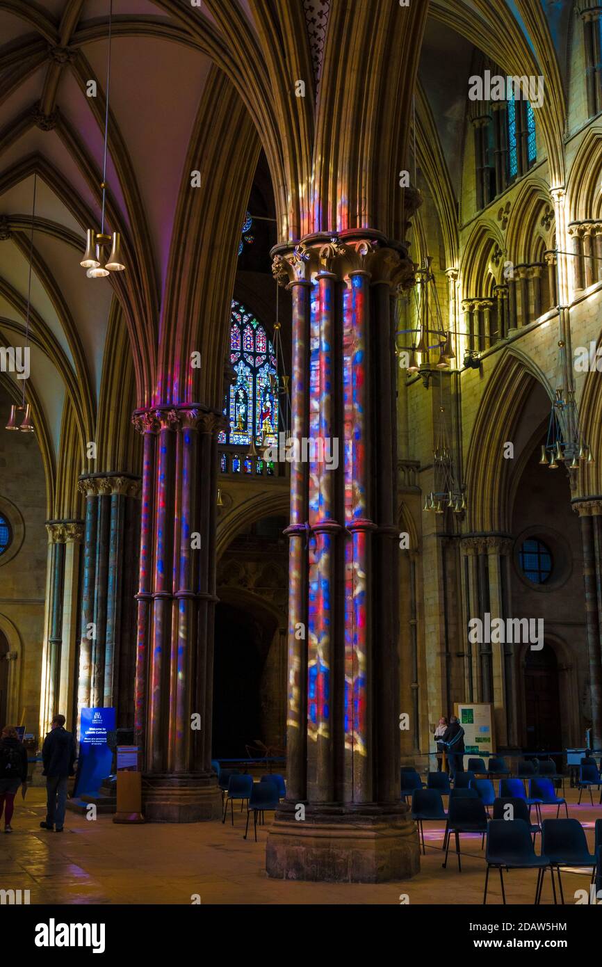 Support columns with stained glass window pattern projected by sunlight ...