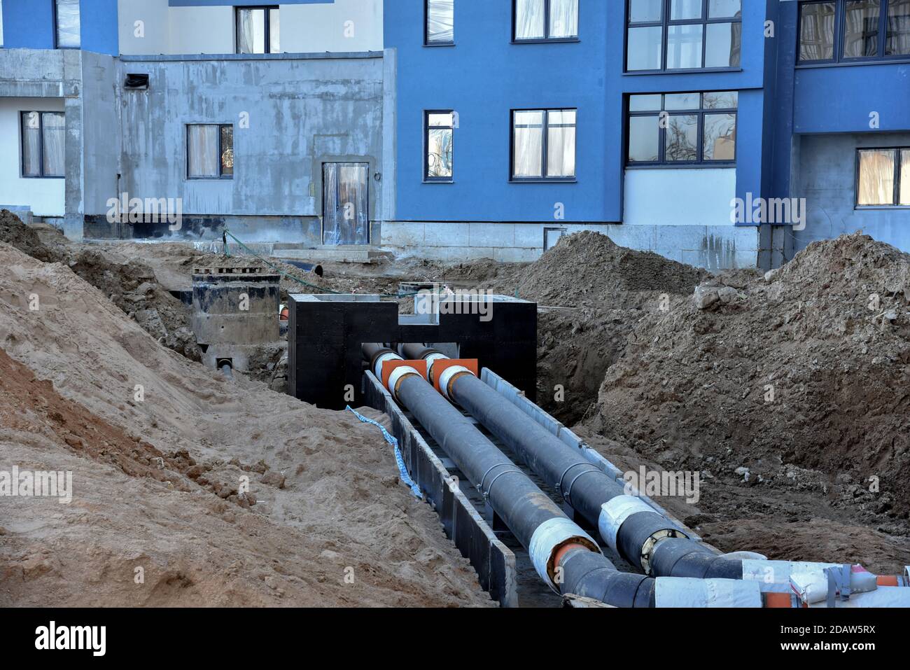 Laying heating pipes in a trench at construction site. Install ...