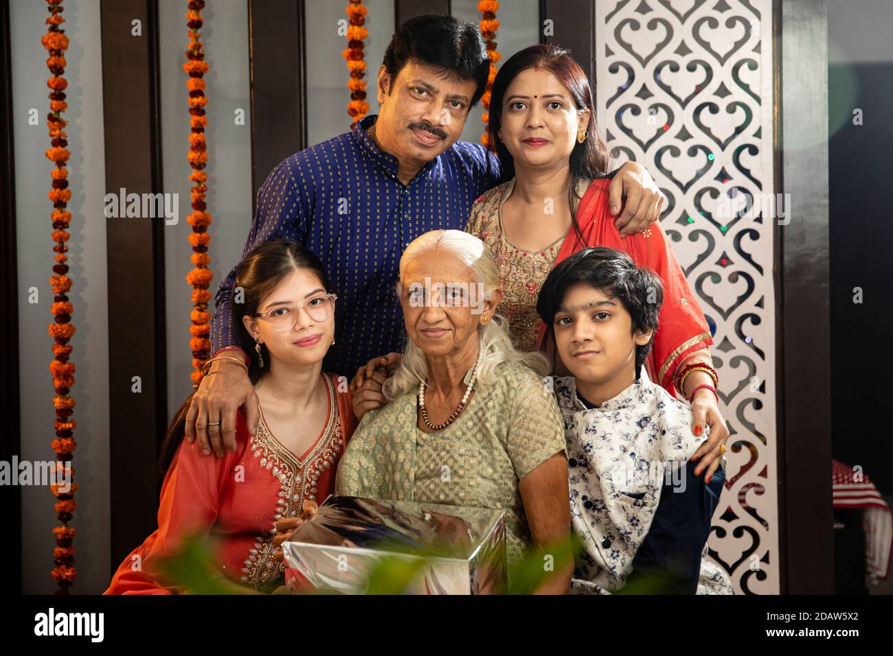 Three generations of an Indian family posing together, parents ...
