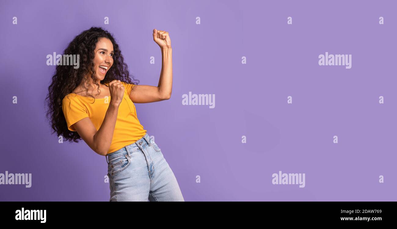 Euphoric brunette woman emotionally celebrating success, raising fists ...