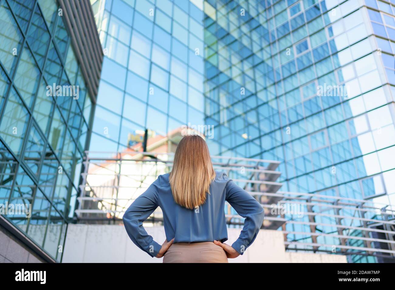Back view of successful manager looking at business building of modern ...